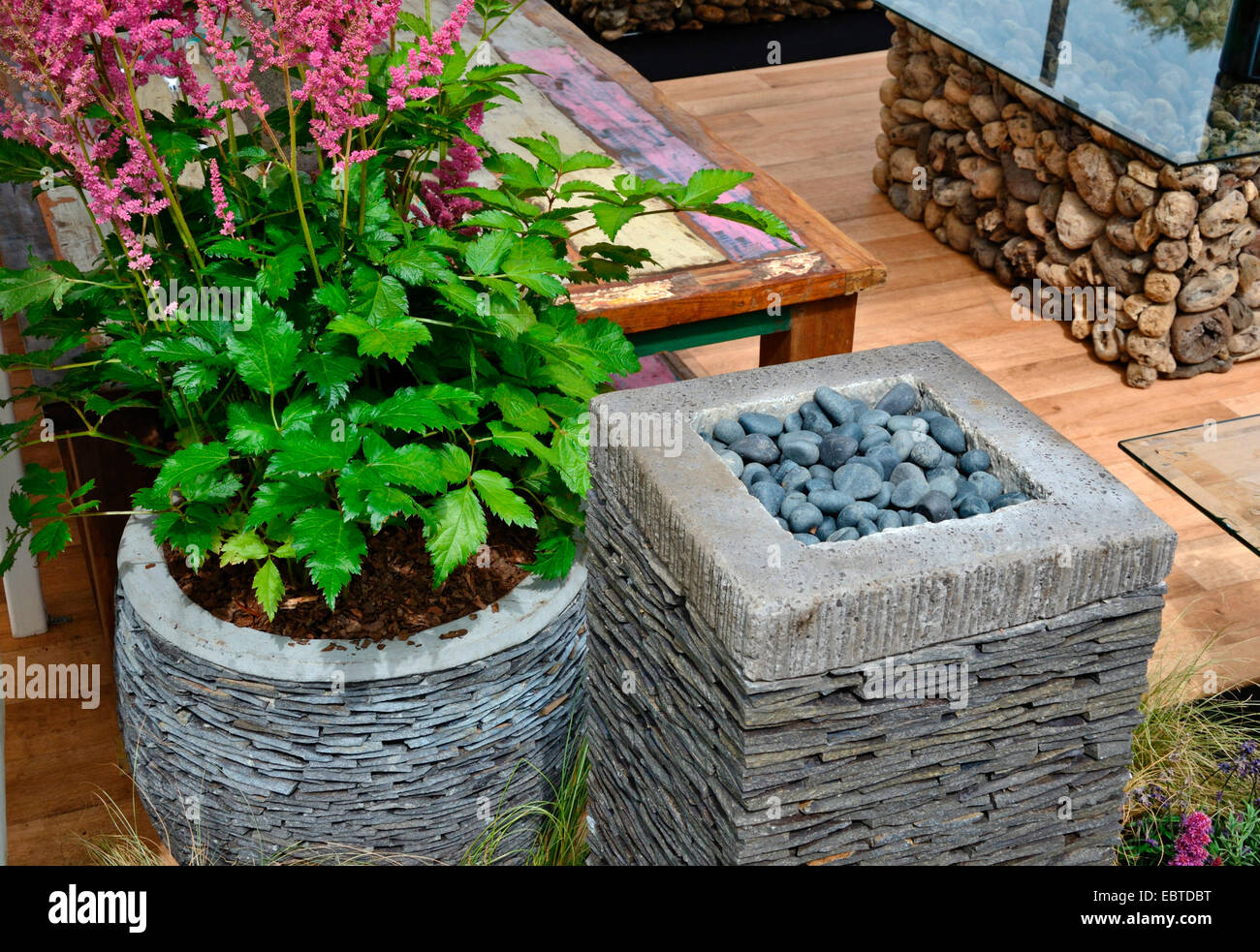 Garden detail of a craft made slate containers with a flowering plants ...