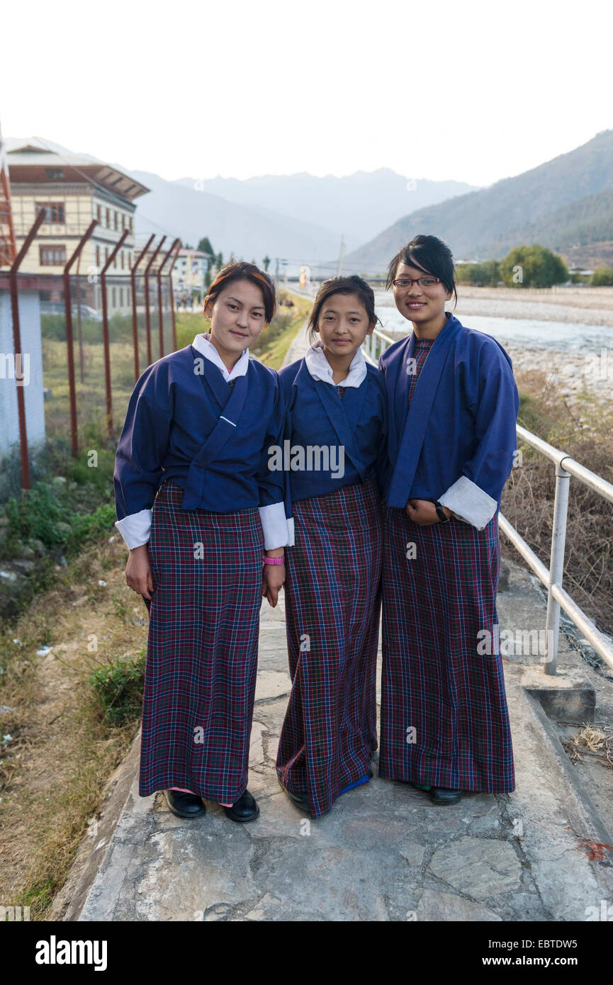 Three secondary school students in uniform at the Paro river bank ...