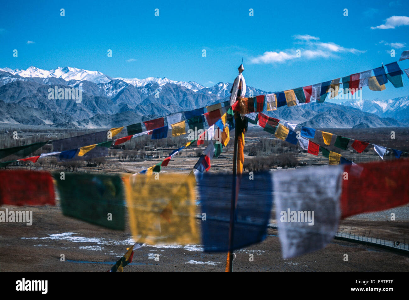 Buddhist coloured prayer flags flap in the wind on a mountain topped ...