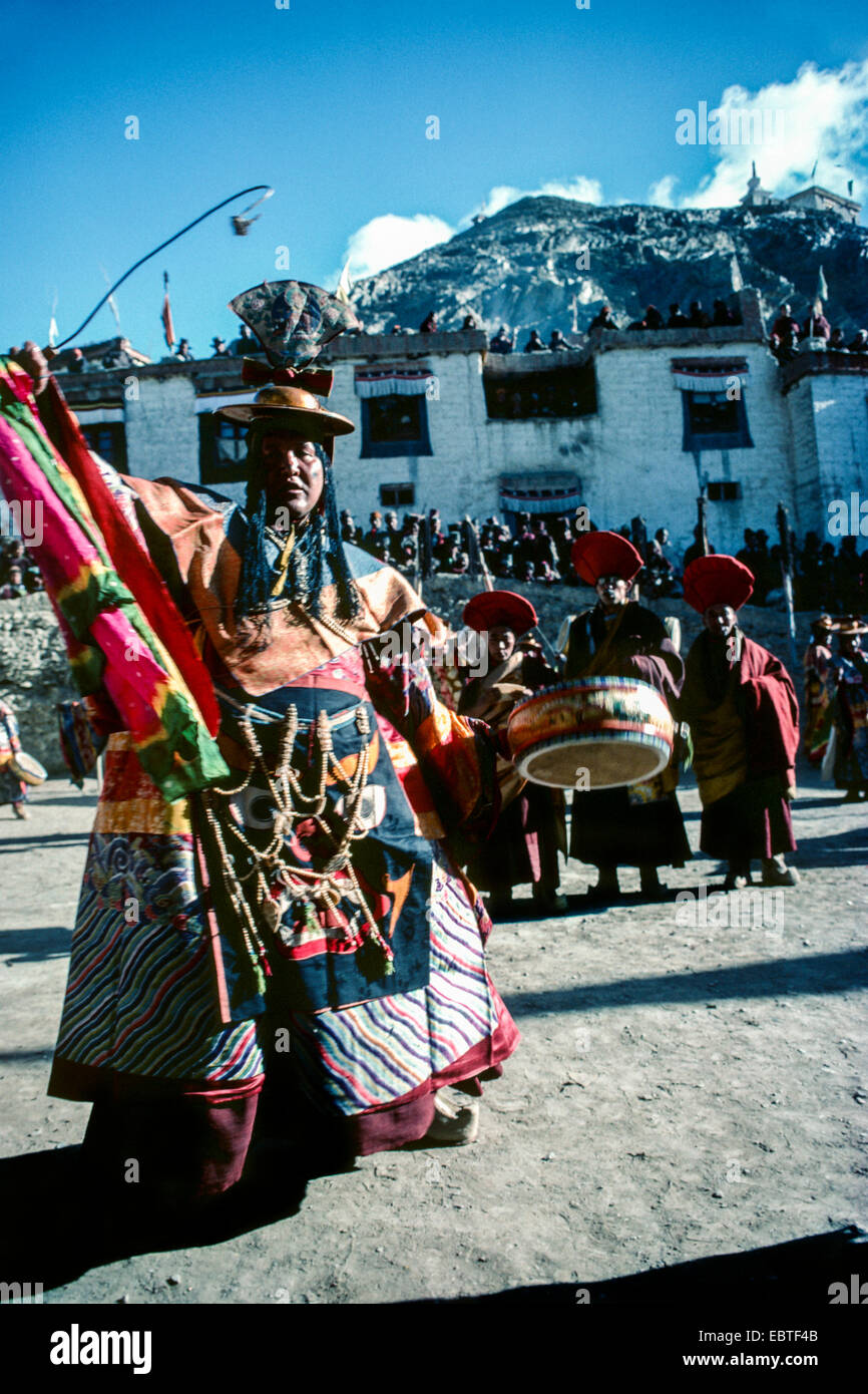 Monks wearing gonchas and red hats play cymbals and drums while a monk ...