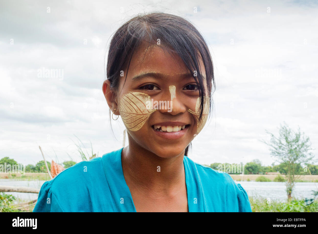 A Burmese girl with Thanaka paste on her face in the shape of a leaf ...