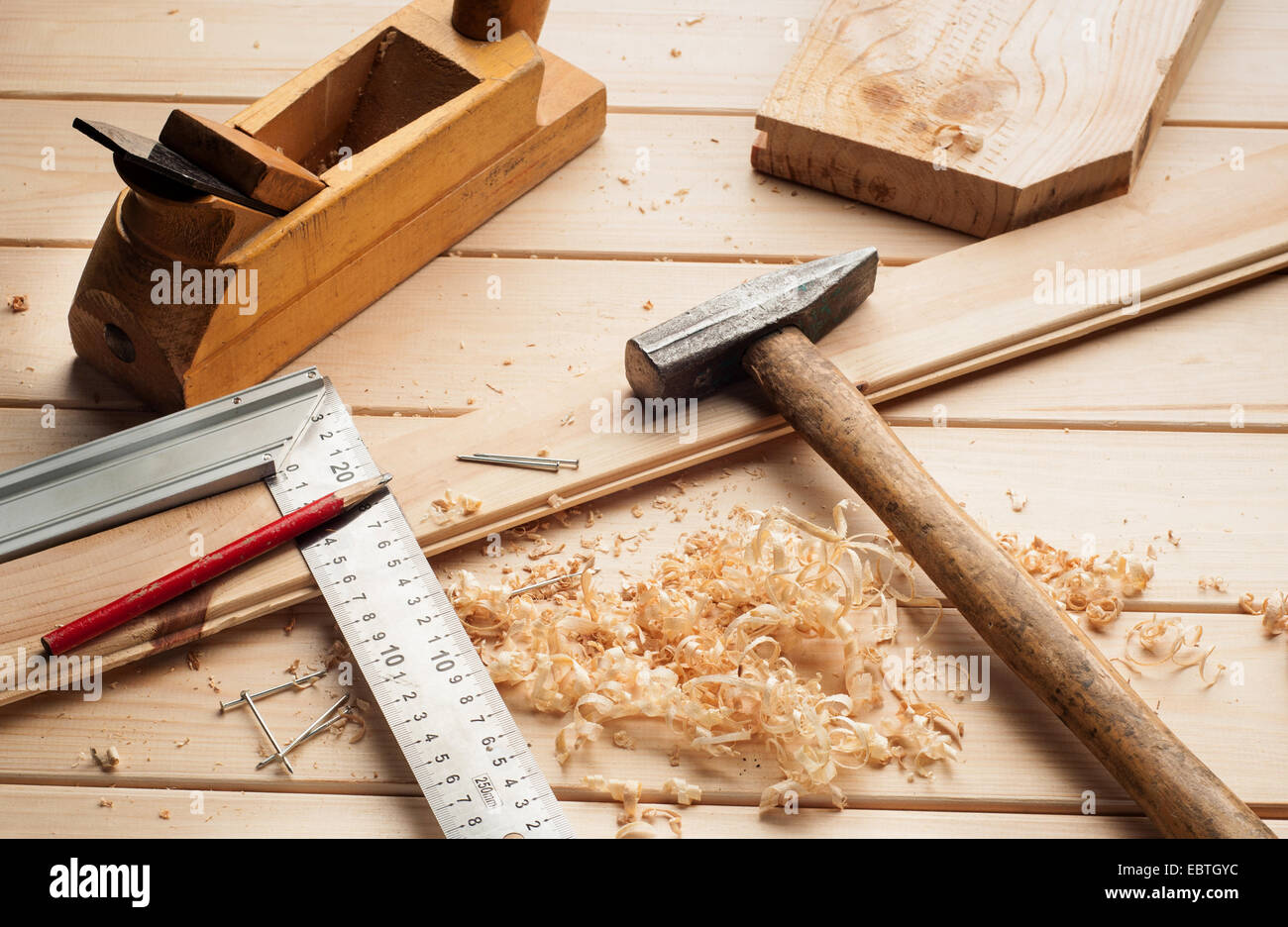 carpenter tools,hammer,meter, nails,shavings, and chisel over wood ...