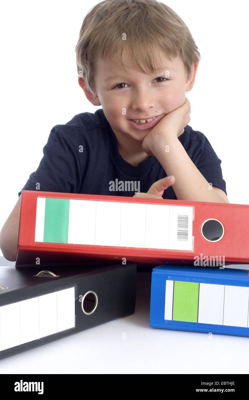 little boy leaning on a stack of files with a smile Stock Photo - Alamy