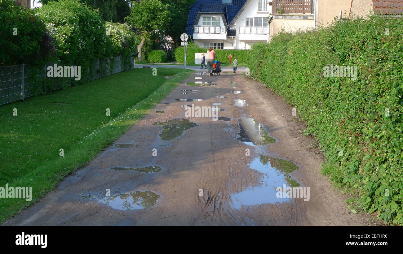 woman walking with buggy on a path with puddles, Germany Stock Photo ...