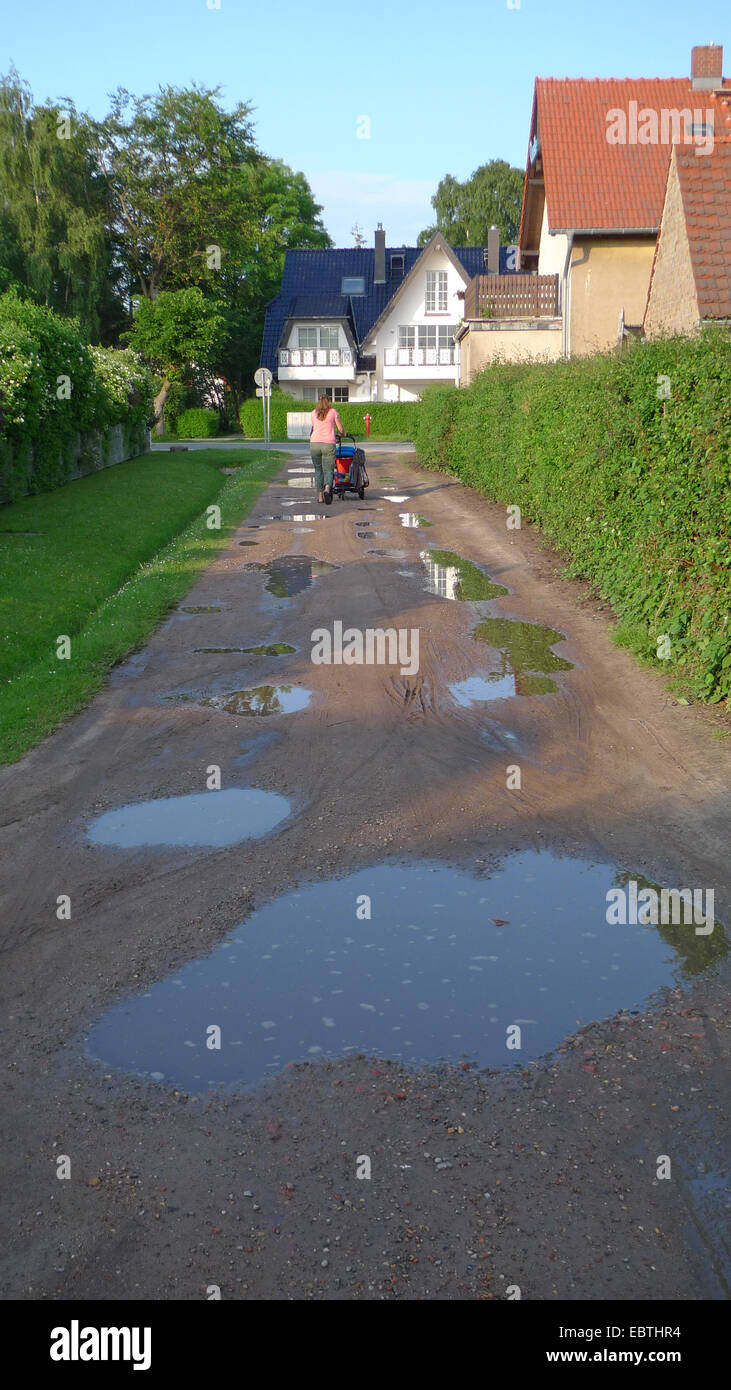 woman walking with buggy on a path with puddles, Germany Stock Photo ...