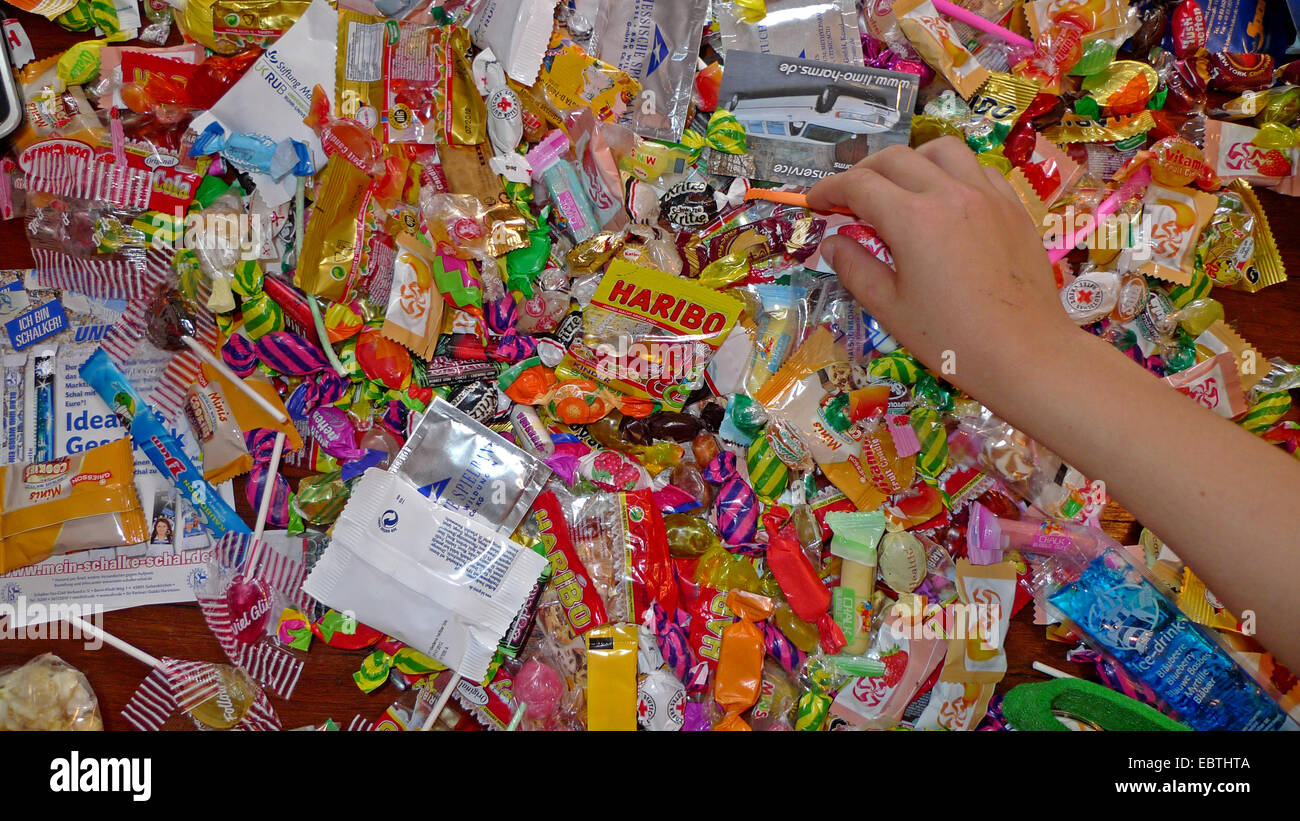 child's hand reaching into a heap of sweets Stock Photo - Alamy