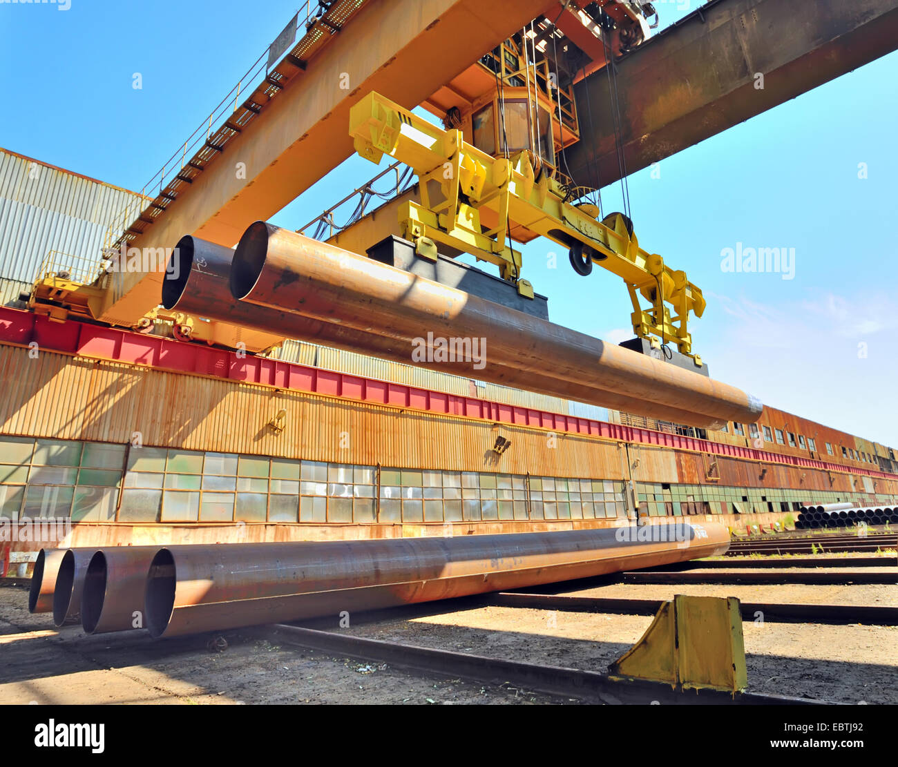 Loading pipes With Bridge Crane on industrial place Stock Photo - Alamy