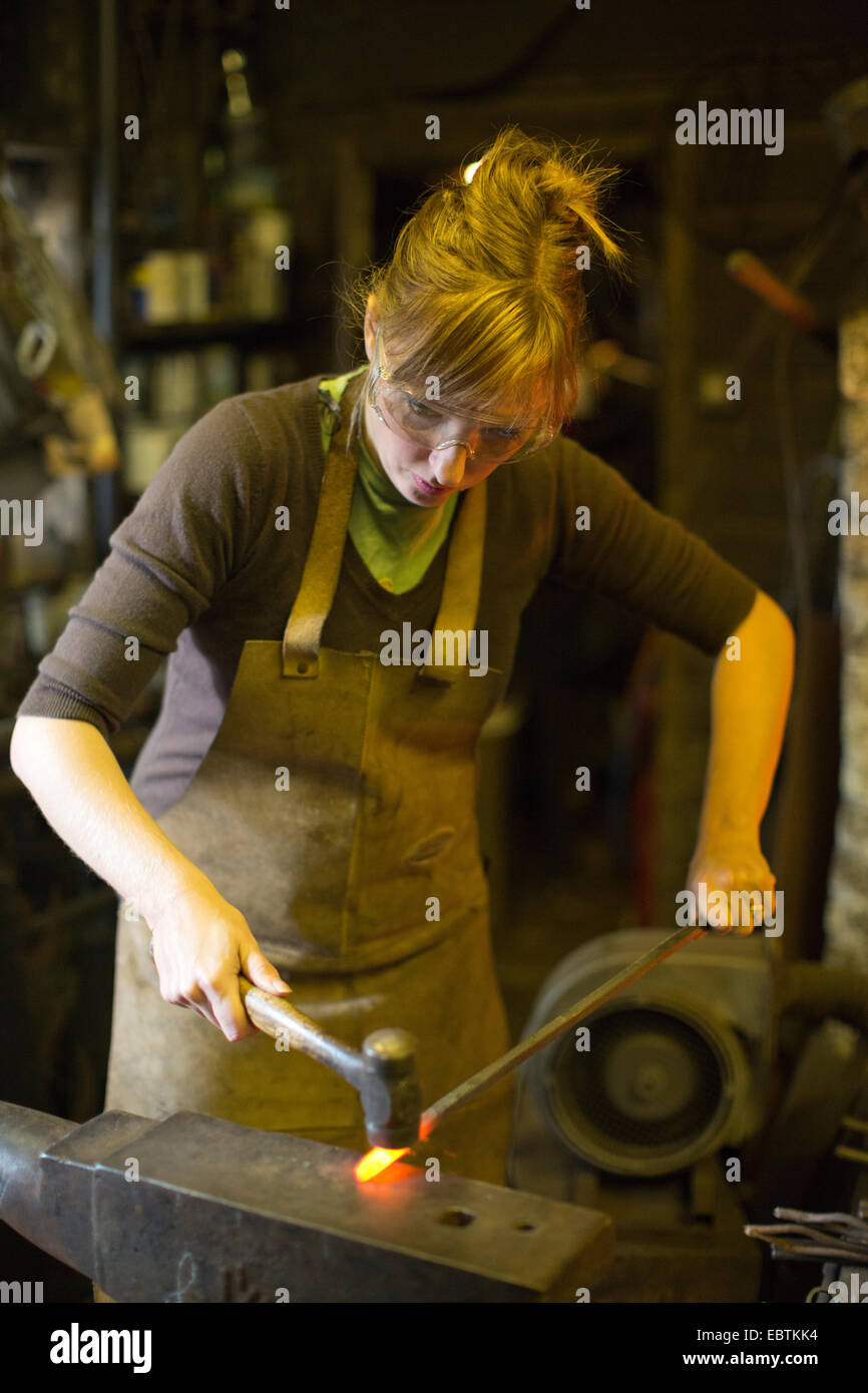 Woman blacksmith working in a forge, Much Hadham, Herfordshire, England ...