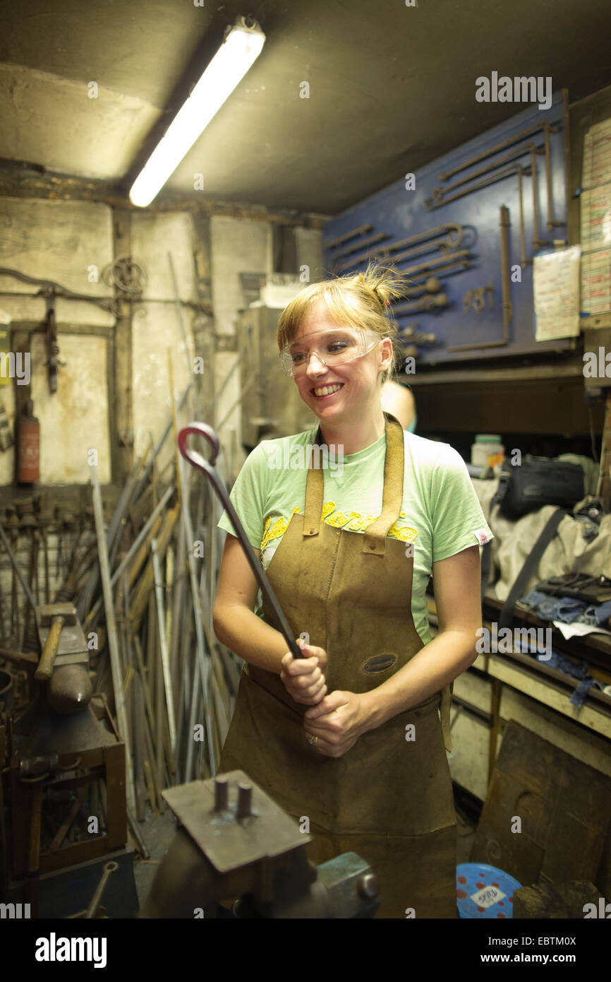 Woman blacksmith working in a forge, Much Hadham, Herfordshire, England ...