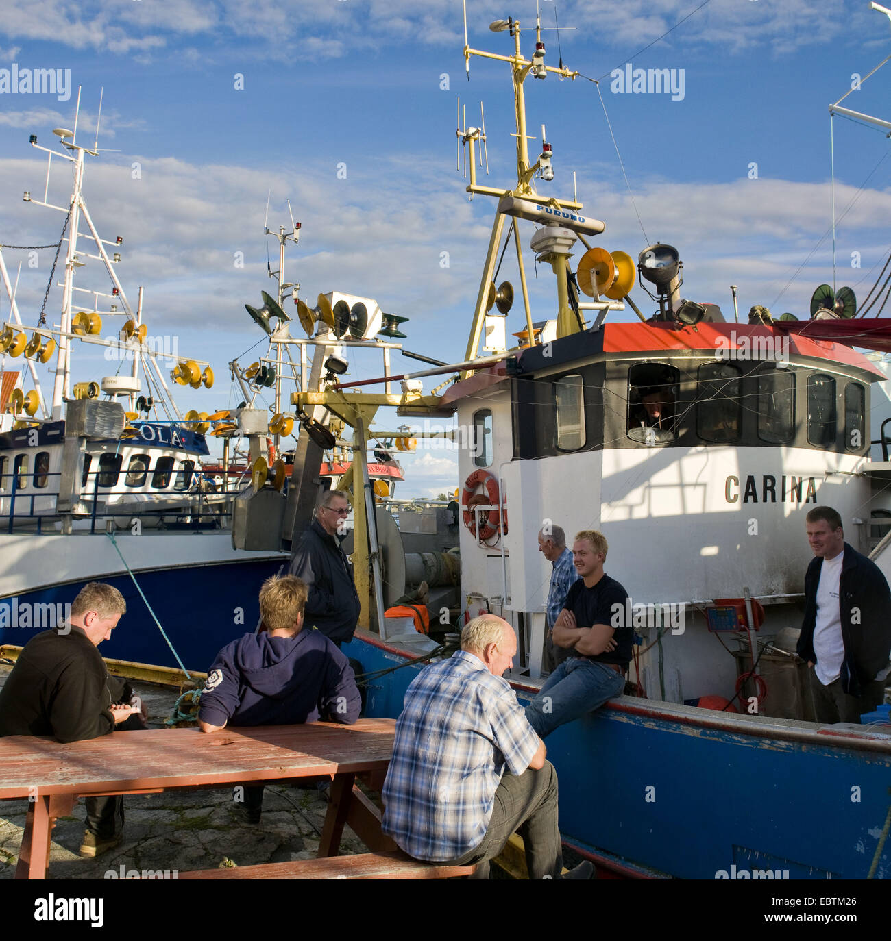 fishermen sitting by a trawler in harbour, Norway, Karmoy, Skudeneshavn ...