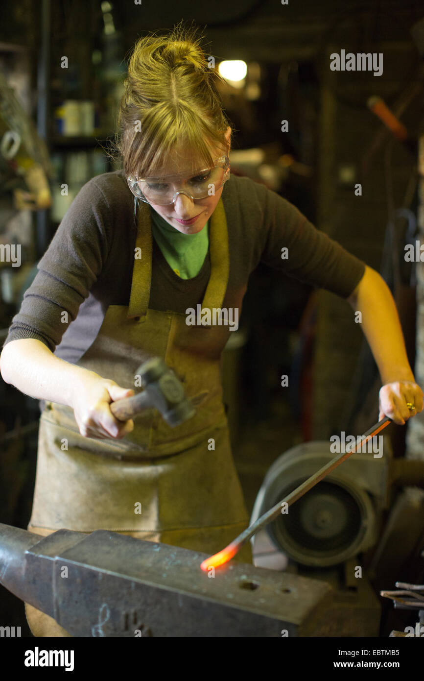 Woman blacksmith working in a forge, Much Hadham, Herfordshire, England ...