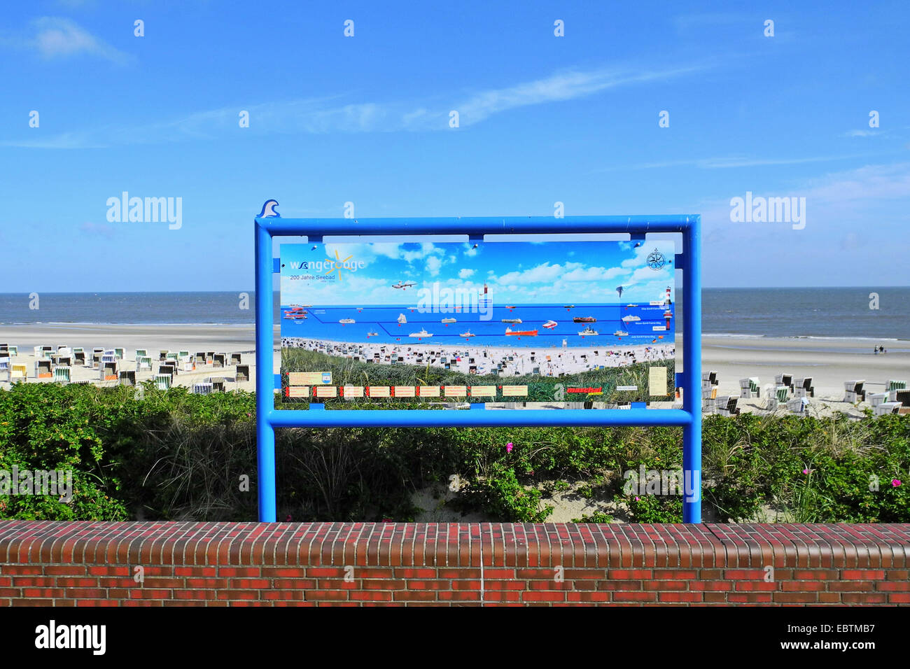 information sign at the promenade in front of a beach covered with ...