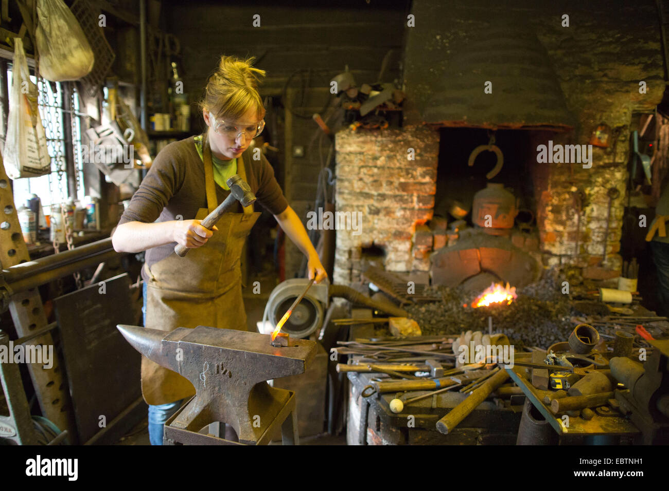 Woman blacksmith working in a forge, Much Hadham, Herfordshire, England ...