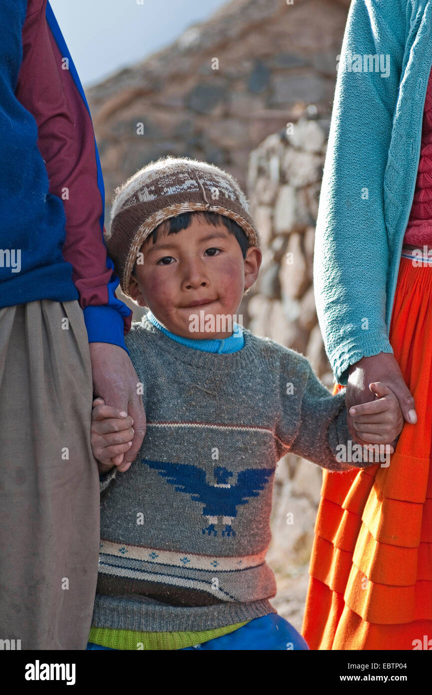 Quechua boy at his parents hands hi-res stock photography and images ...