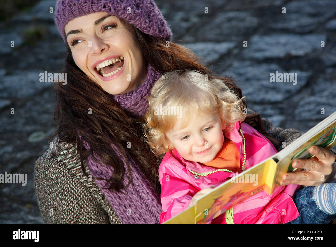young woman with little girl reading a book Stock Photo - Alamy