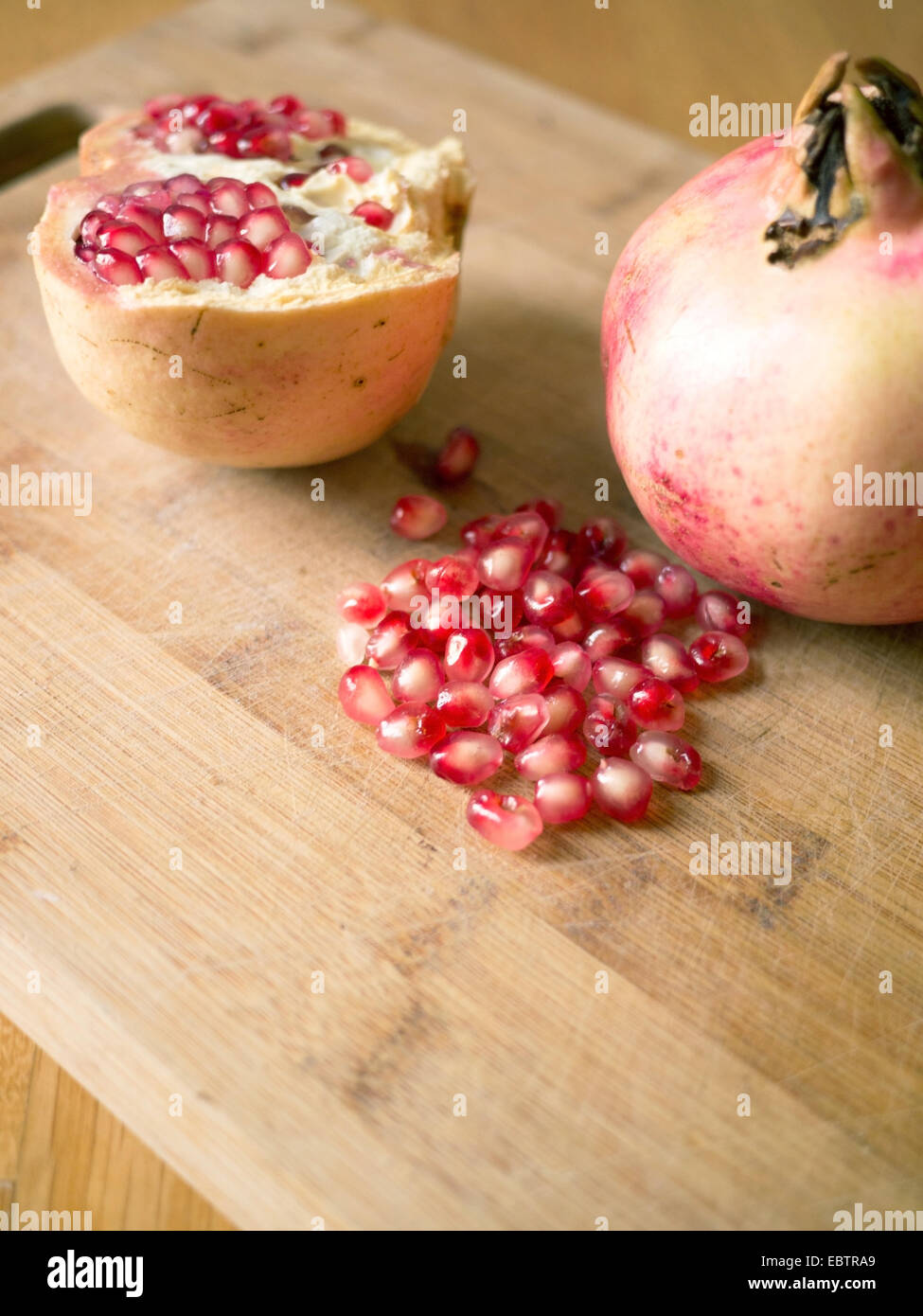 Ripe pomegranates on wooden board Stock Photo - Alamy