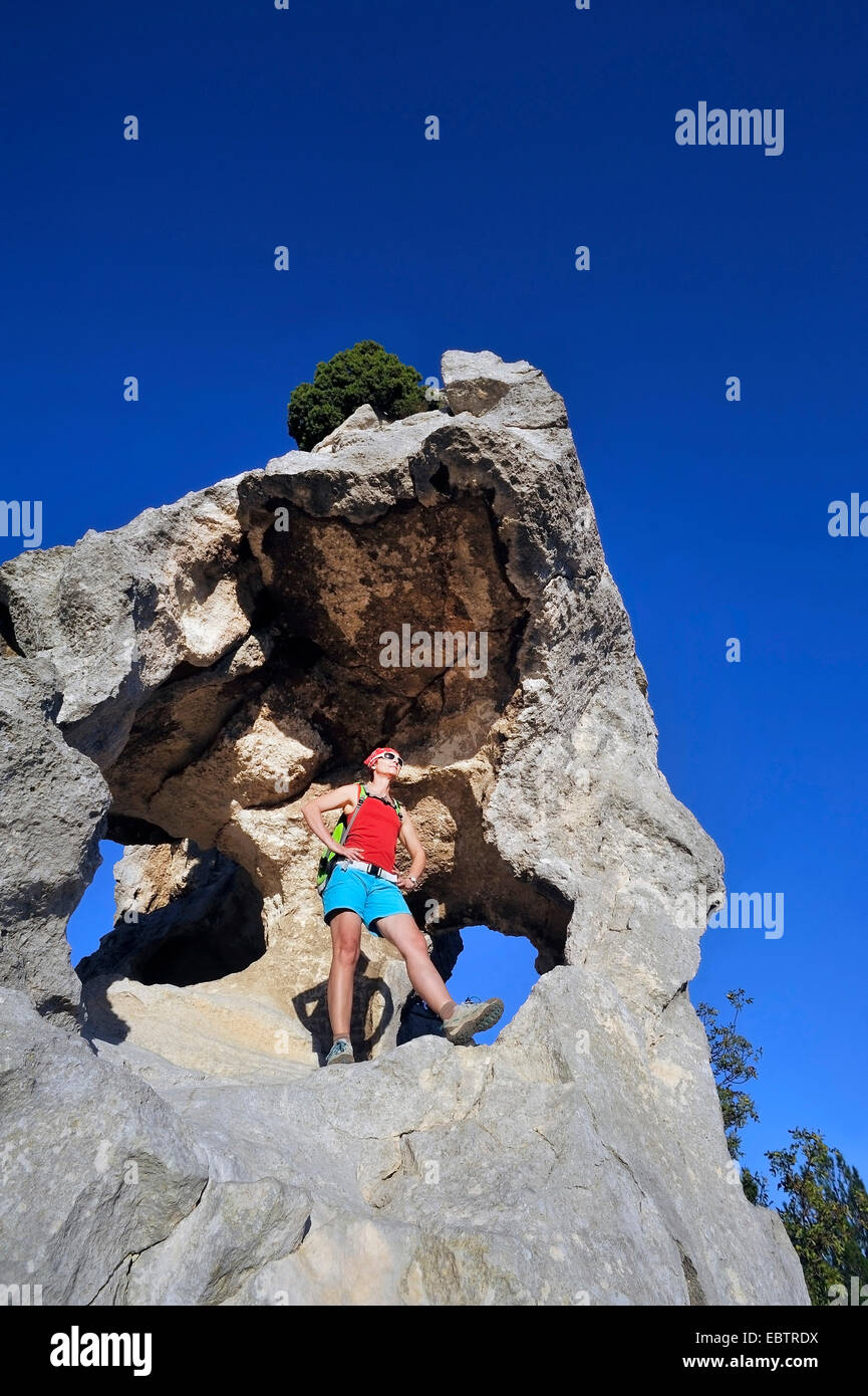 female wanderer standing at a weirdly shaped rock formation, France ...