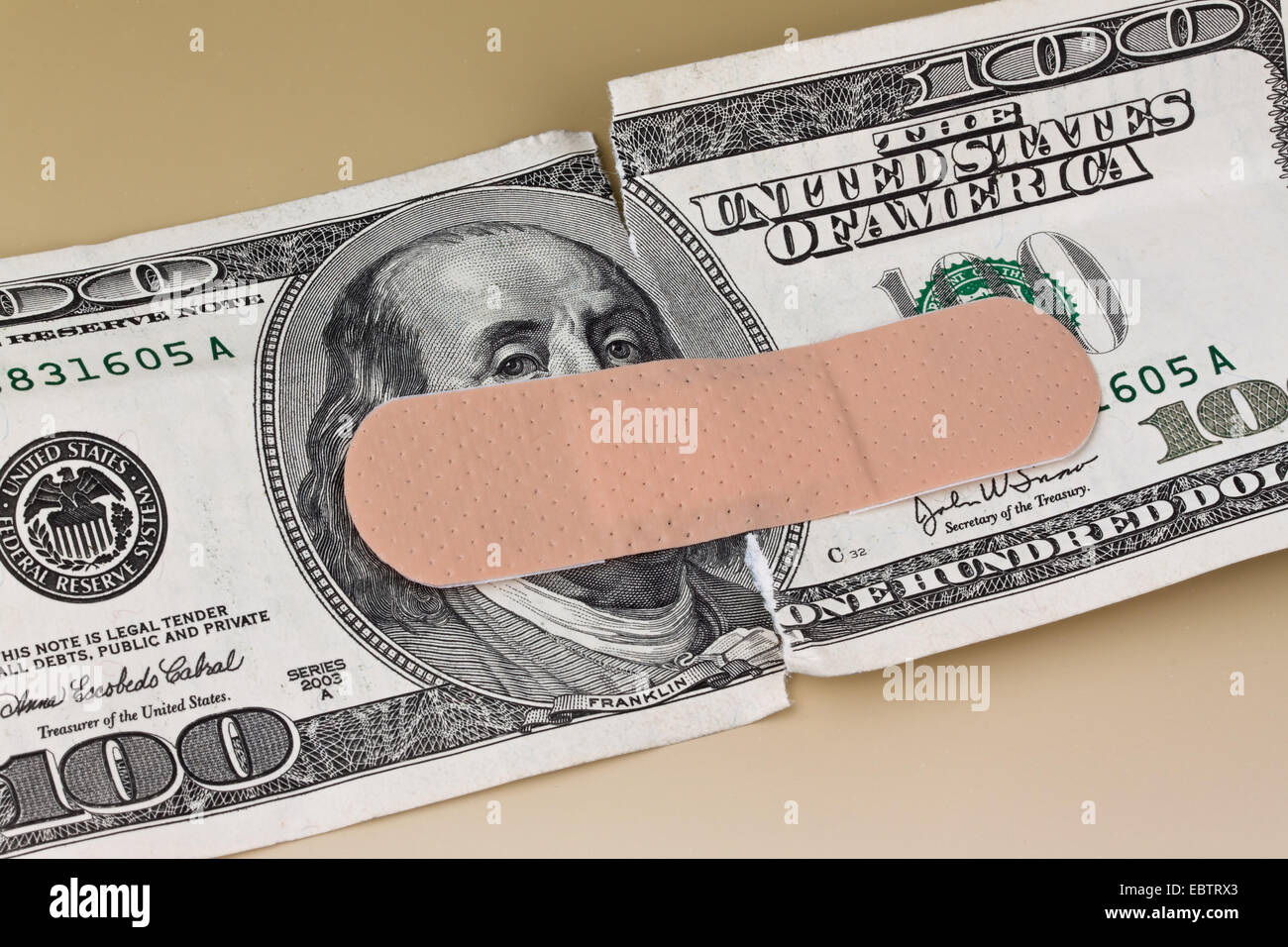 Ripped dollar banknote with a band aid hi-res stock photography and ...