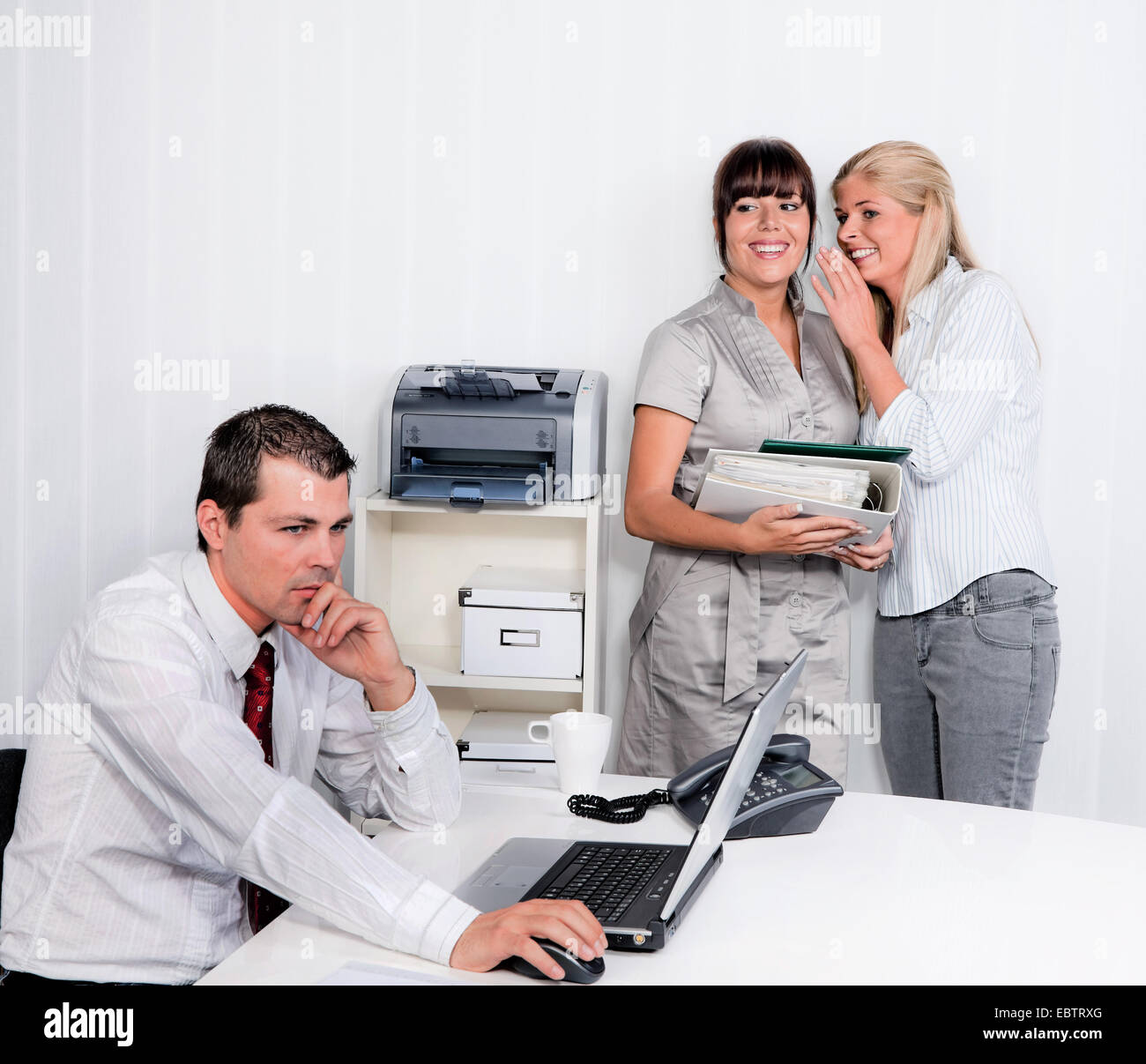 bullying in an office, two women laughing at a man Stock Photo - Alamy