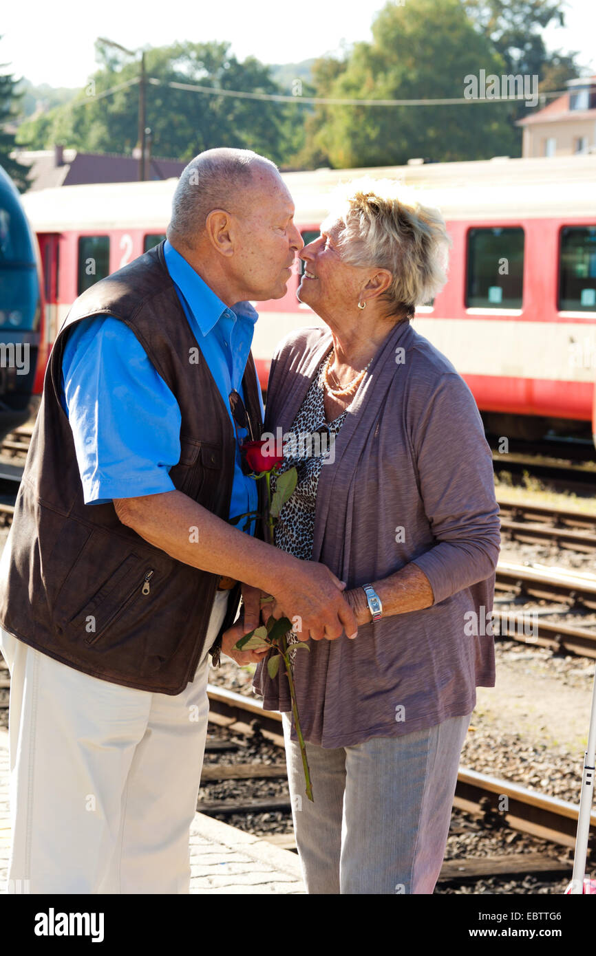 older couple, man saying good bye to the woman at the train plattform ...