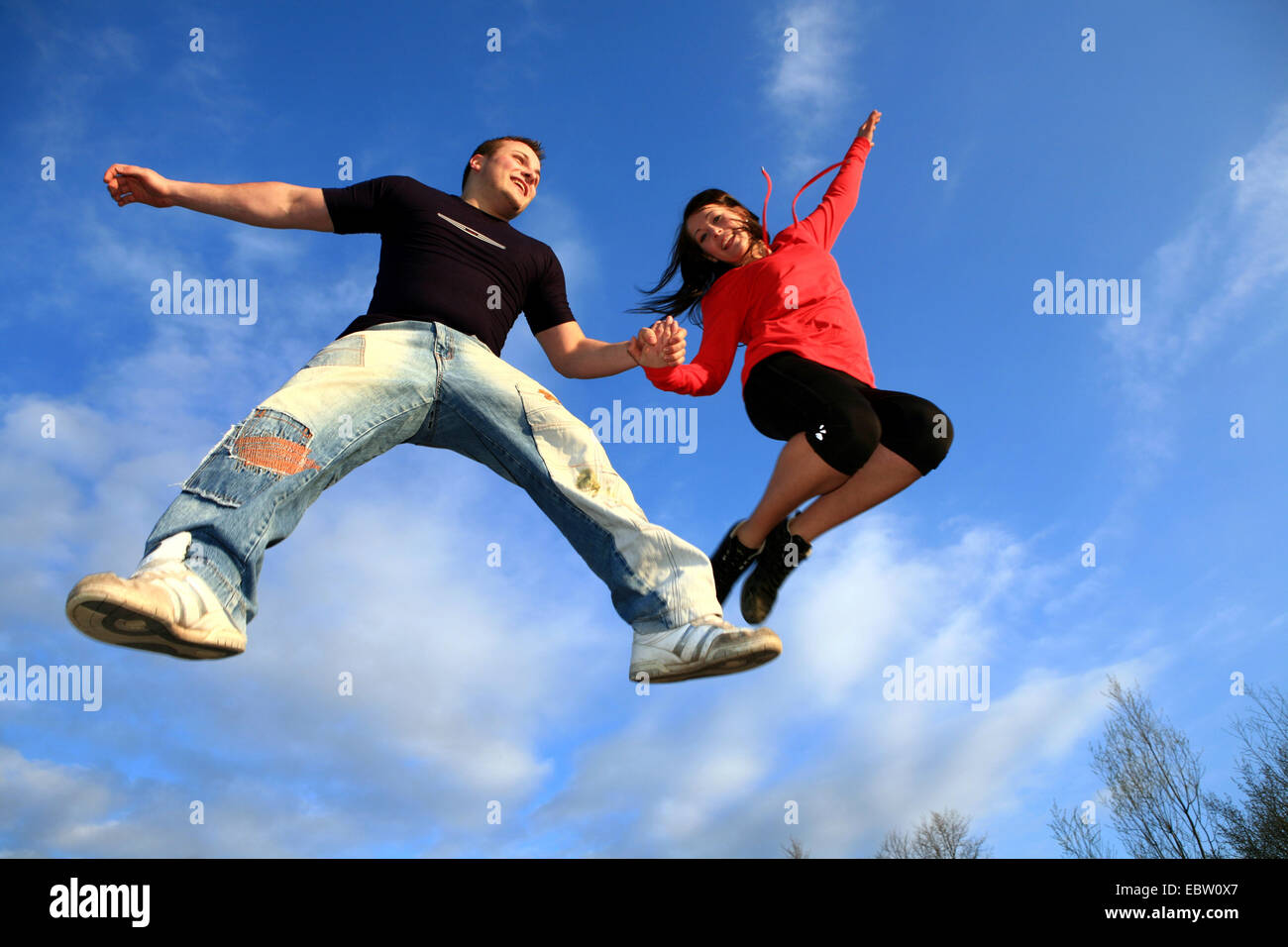 young man and young woman jumping up, Germany Stock Photo - Alamy