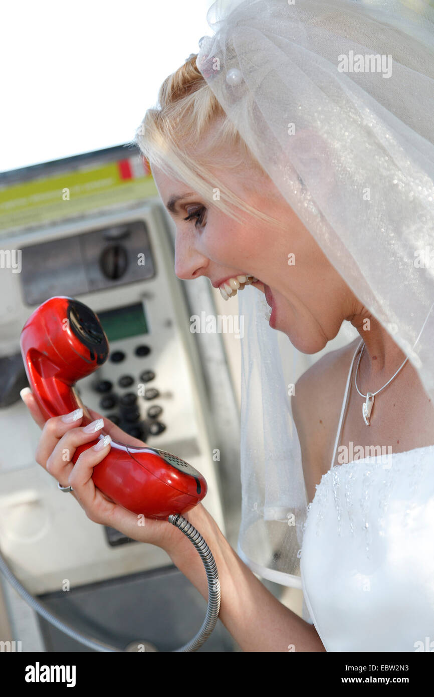 happy bride making a call in phone booth Stock Photo - Alamy