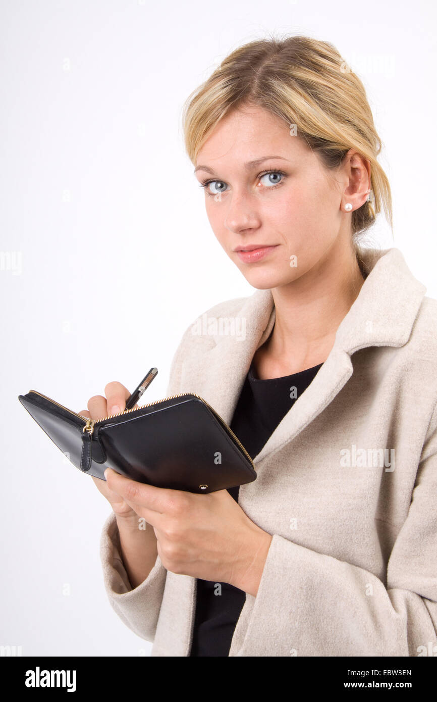 young woman making a note in her notebook Stock Photo - Alamy