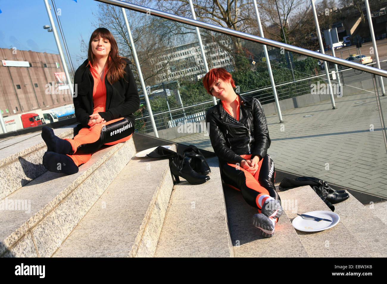 two tired hostesses resting on stairs, Germany, North Rhine-Westphalia ...
