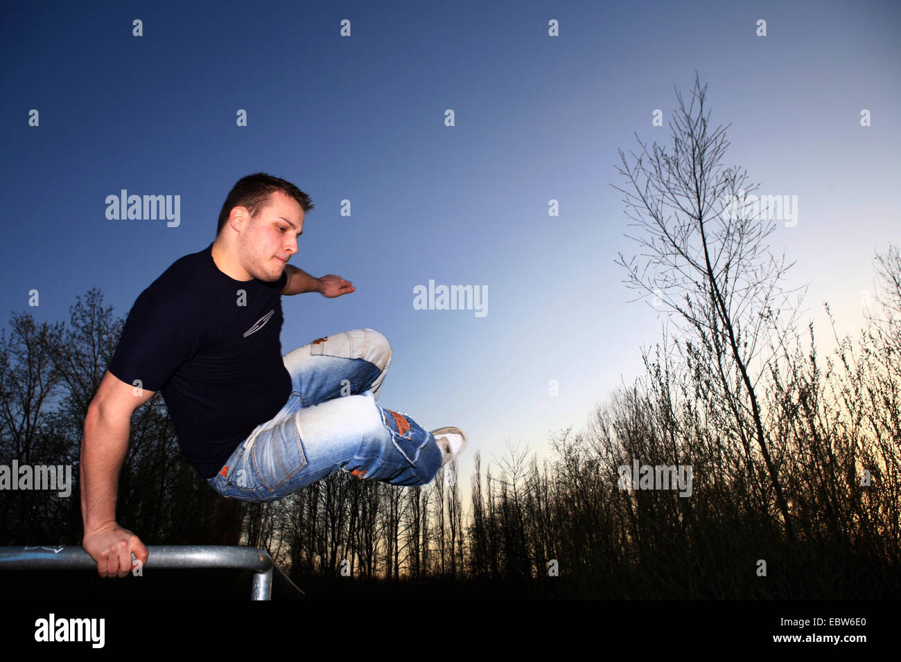 Young man jumping over railing hi-res stock photography and images - Alamy