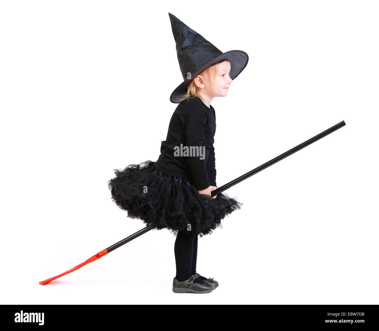 little girl in witch costume riding on a broom Stock Photo - Alamy