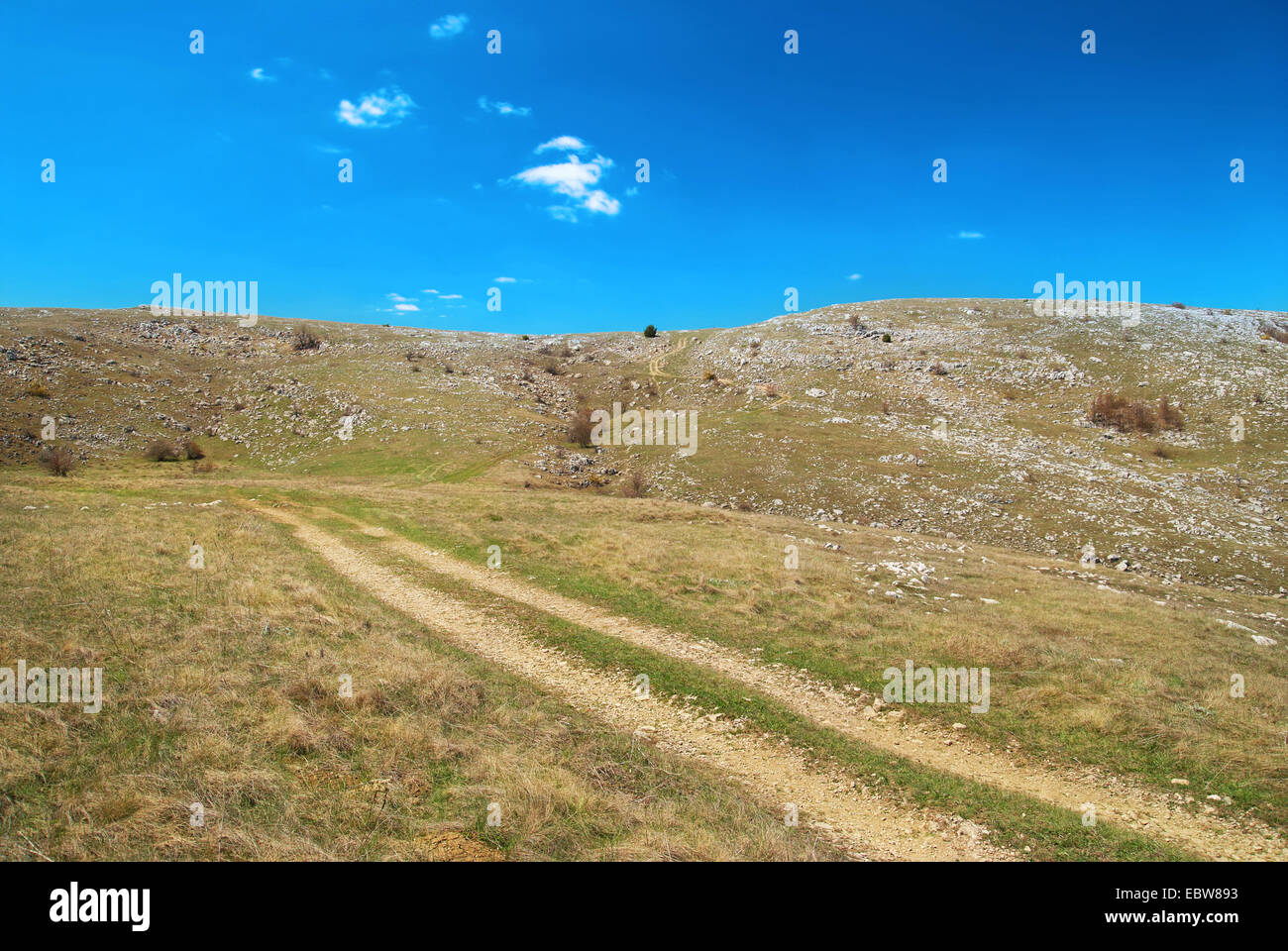 Road over hills with cloudscape and blue sky Stock Photo - Alamy