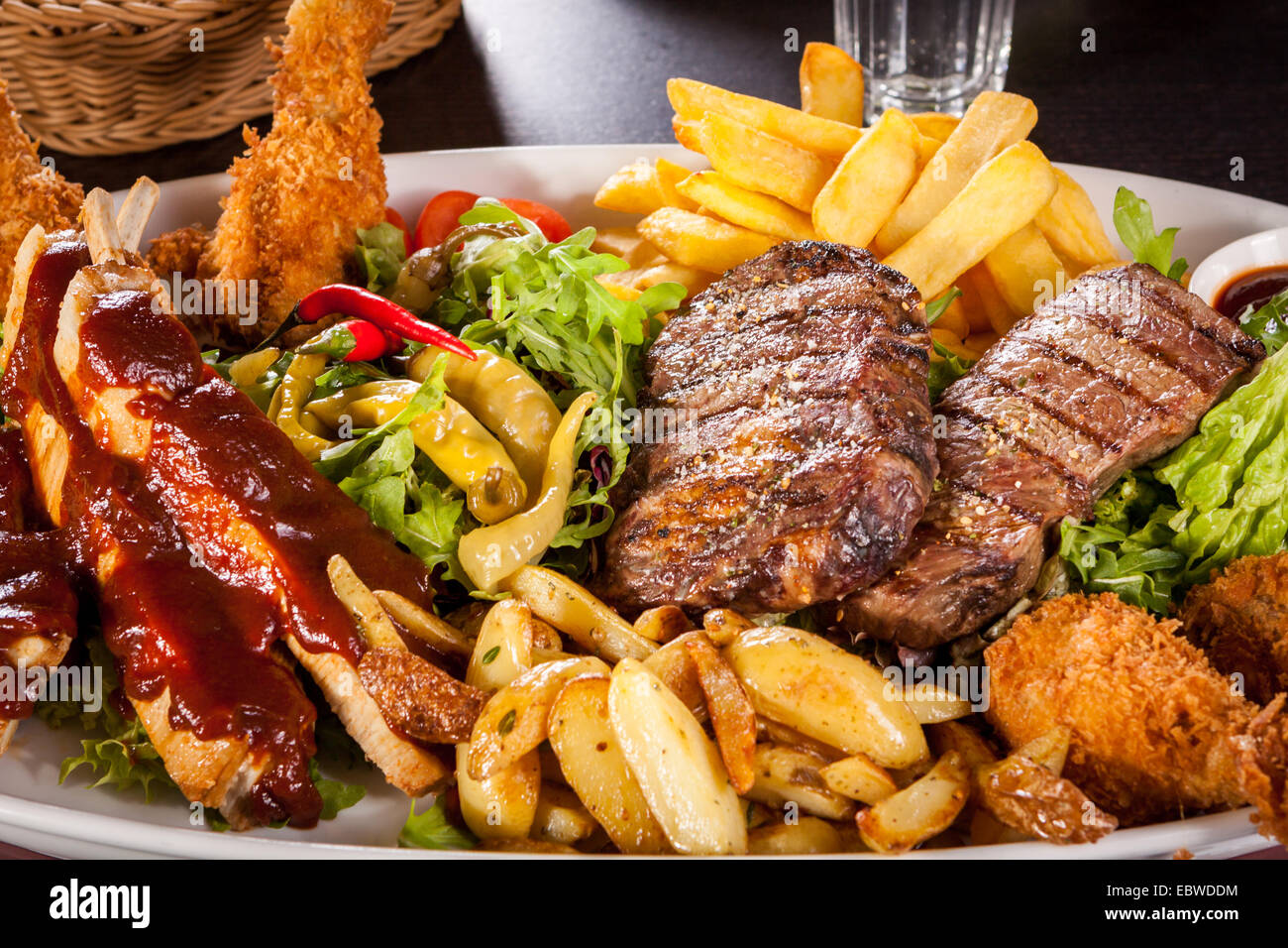 Wholesome platter of mixed meats including grilled steak, crispy ...