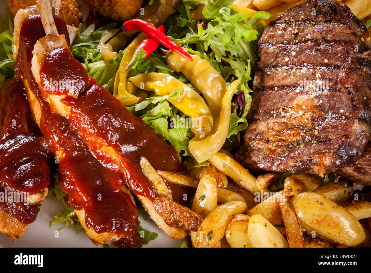 Wholesome platter of mixed meats including grilled steak, crispy ...