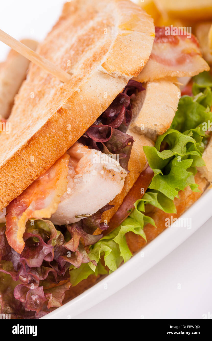 Club sandwich on toasted white bread with a meat filling served with ...