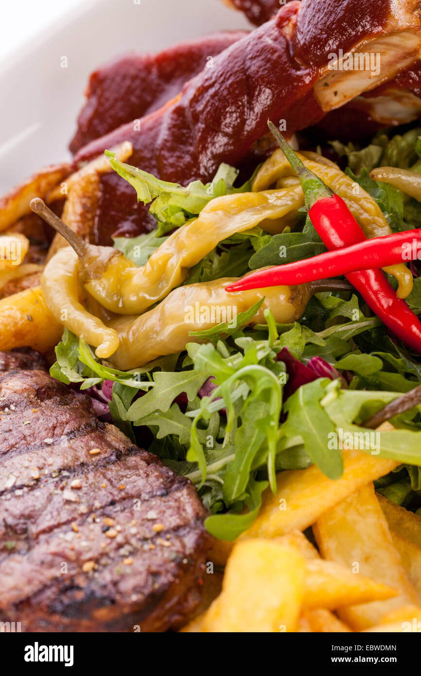 Wholesome platter of mixed meats including grilled steak, crispy ...