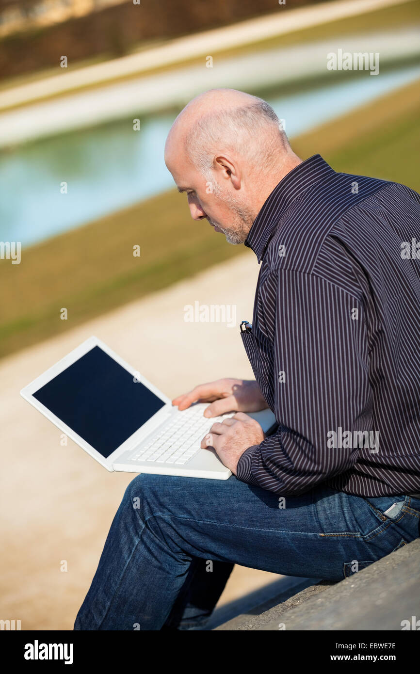 Confident attractive middle-aged man standing waiting in a rural lane ...