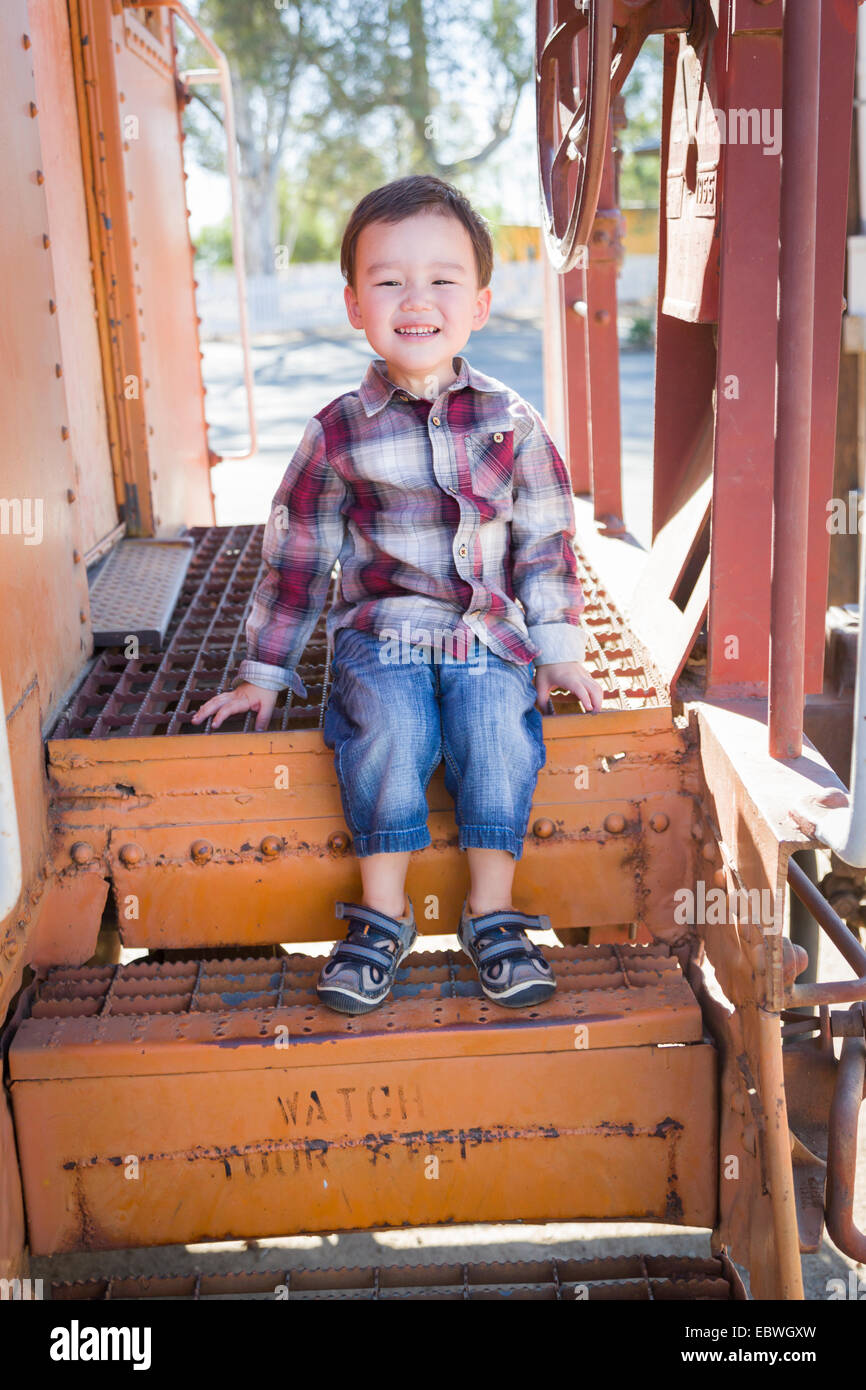 Cute Young Mixed Race Boy Having Fun Outside Sitting on Railroad Car ...