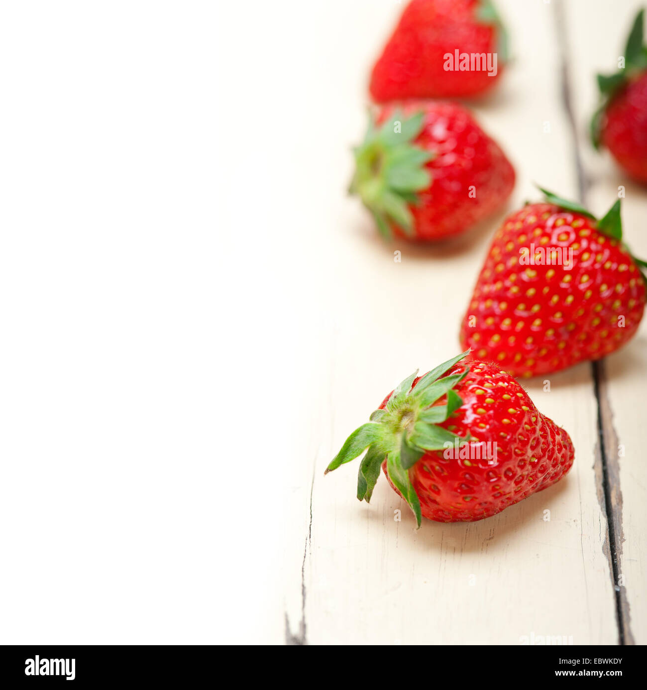 fresh organic strawberry over white rustic wood table Stock Photo - Alamy