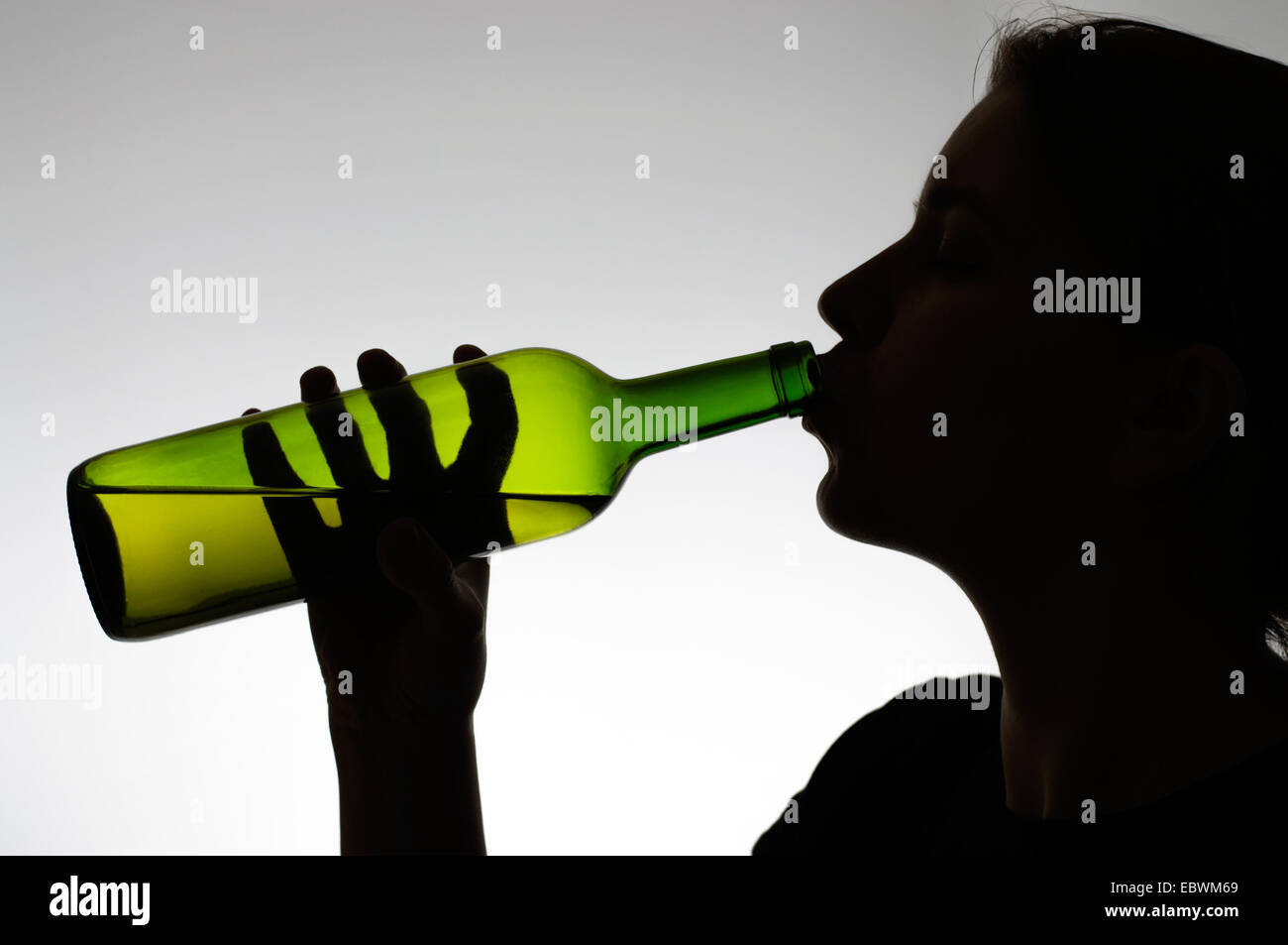 Silhouette of a woman drinking wine from a bottle Stock Photo - Alamy