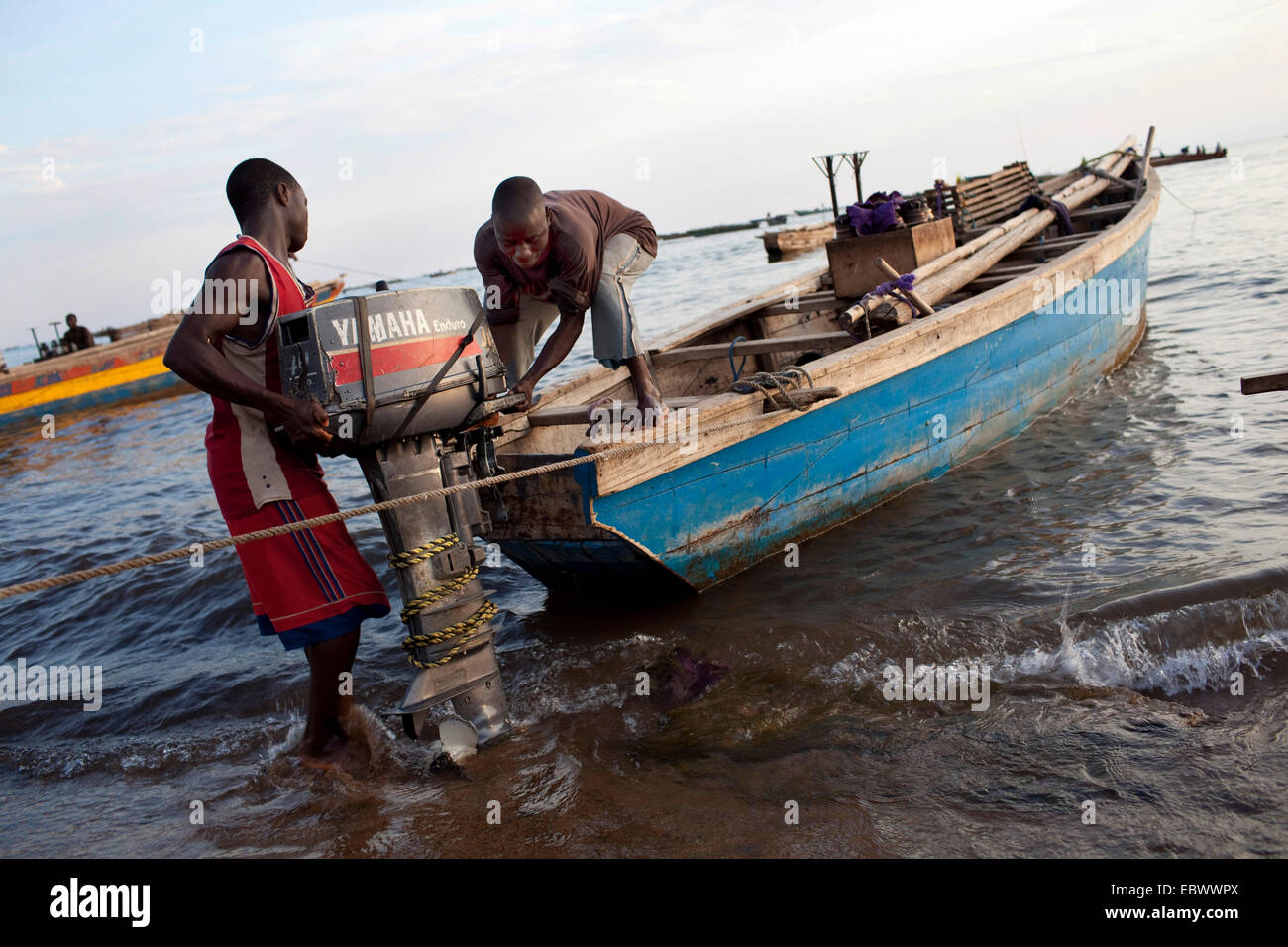 fishermen fixing engine at traditional fishing boat, Burundi, Mvugo ...