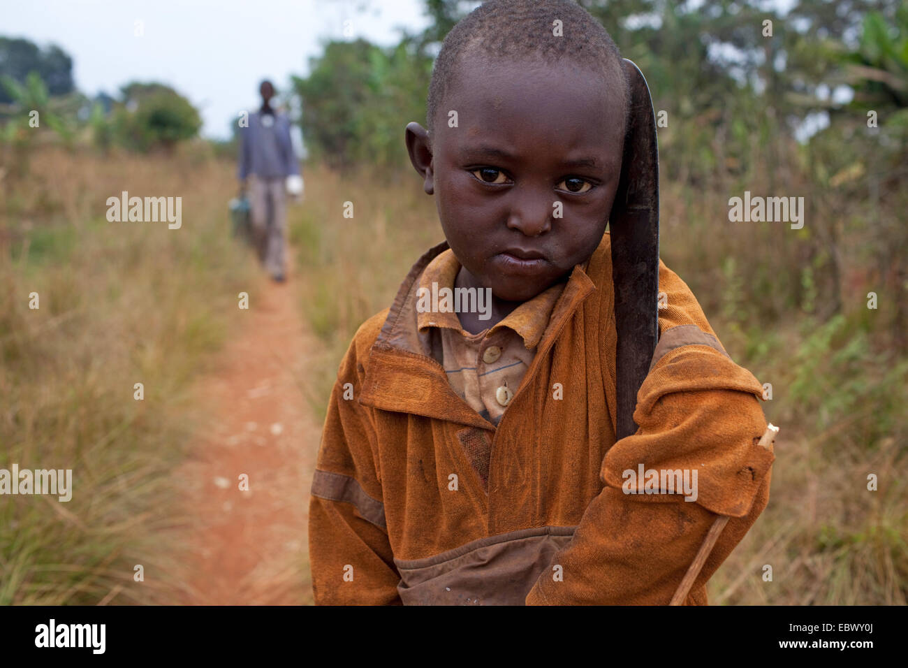 little boy with machete, man on path in background, Burundi, Karuzi ...
