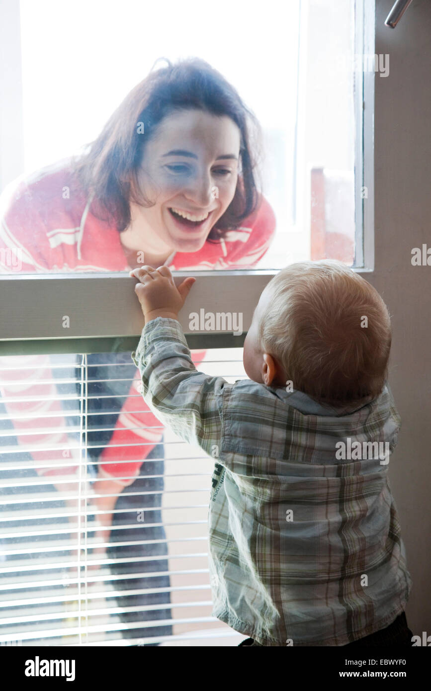 little boy and mother watching through window glasses Stock Photo - Alamy
