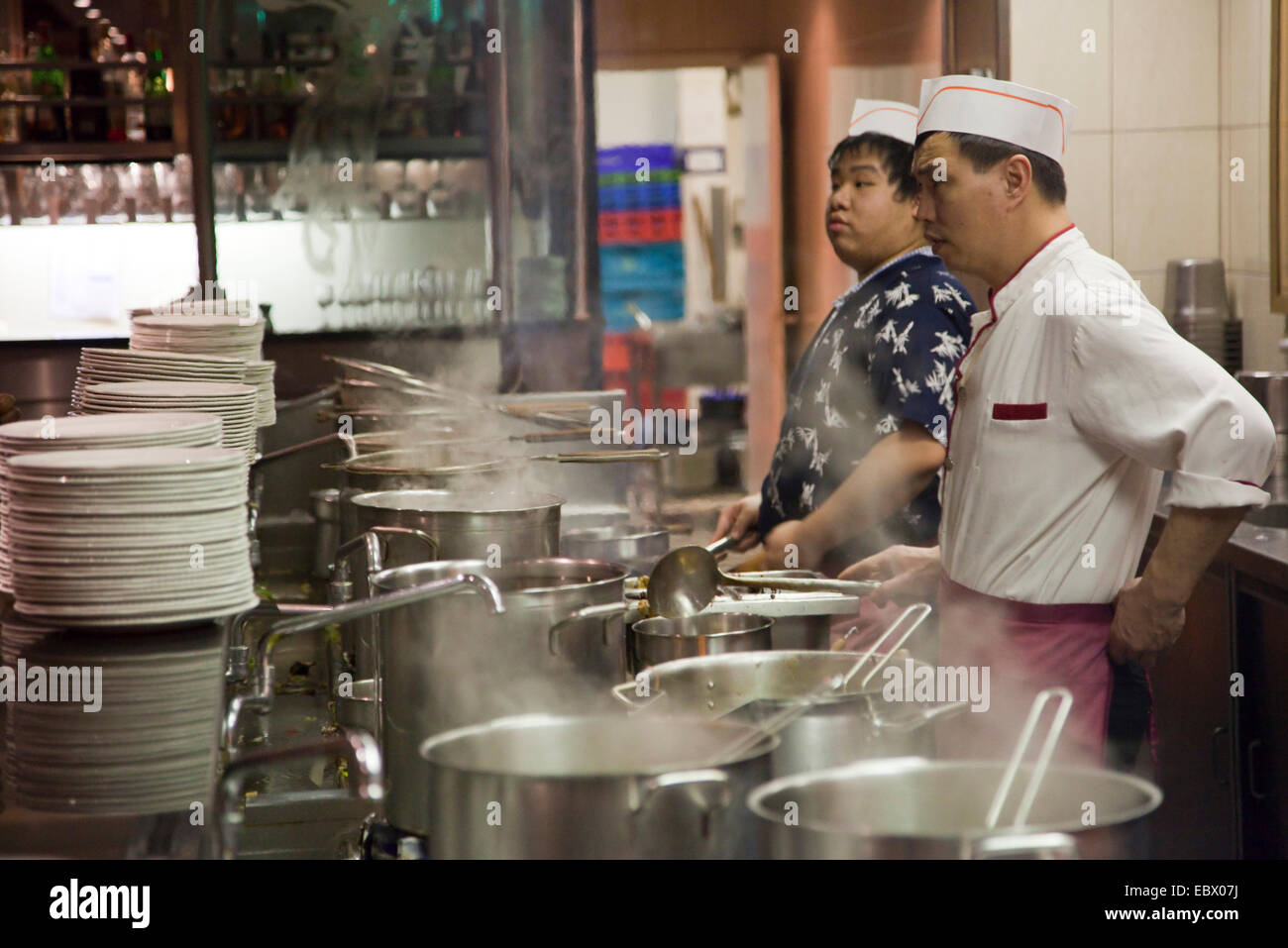 two cooks in the kitchen of a Mongolian restaurant Stock Photo - Alamy