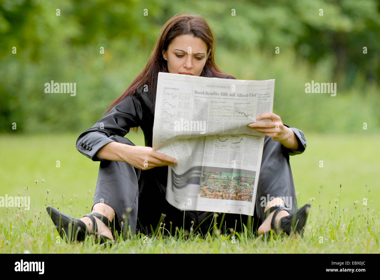 young woman reading a newspaper in a meadow Stock Photo - Alamy