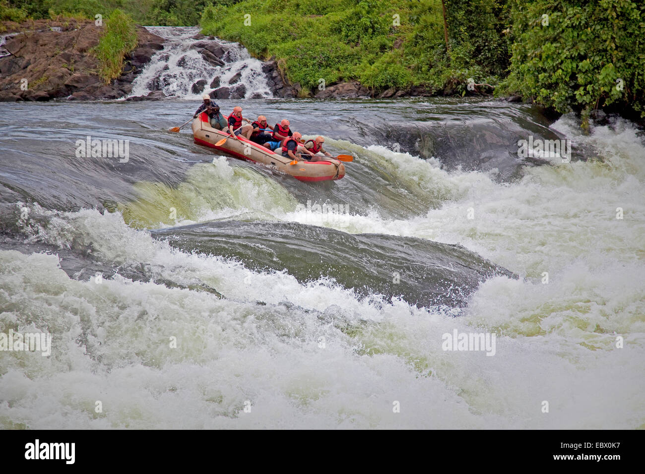 tourists with a local guide are rafting down the Bujagali waterfalls ...
