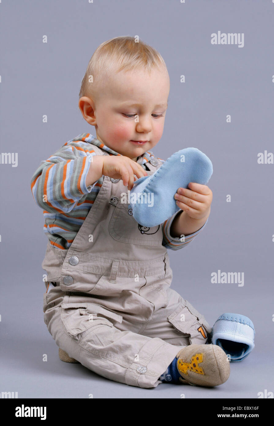 little boy inspecting a shoe, Germany Stock Photo - Alamy