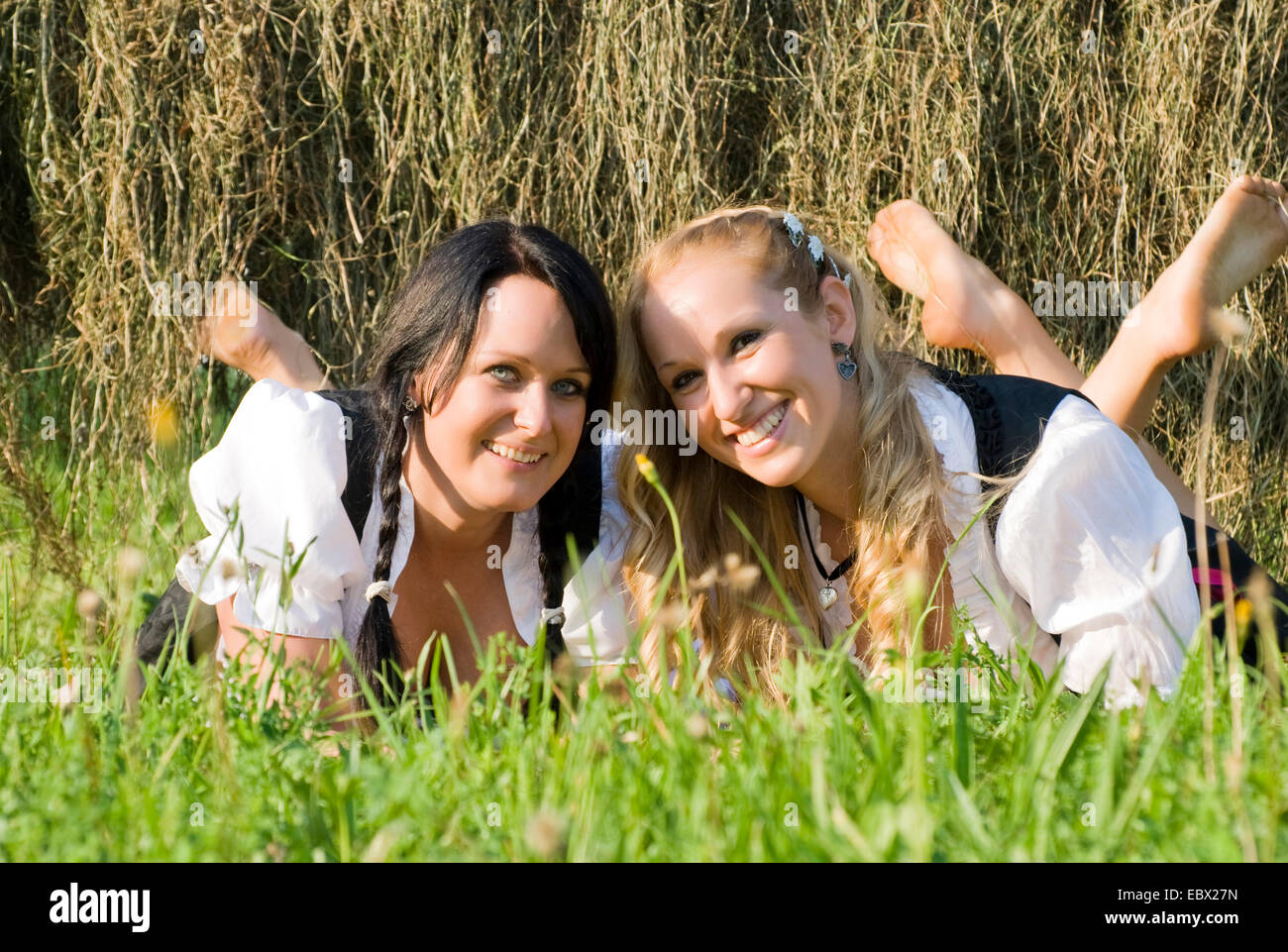 two women in traditional clothing lying in meadow, Austria Stock Photo ...