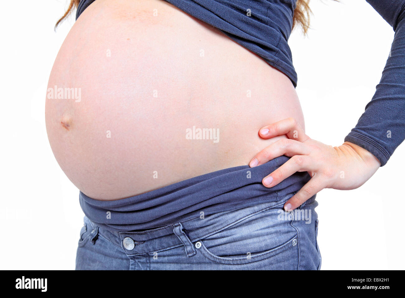 pregnant woman presenting her bare belly Stock Photo - Alamy