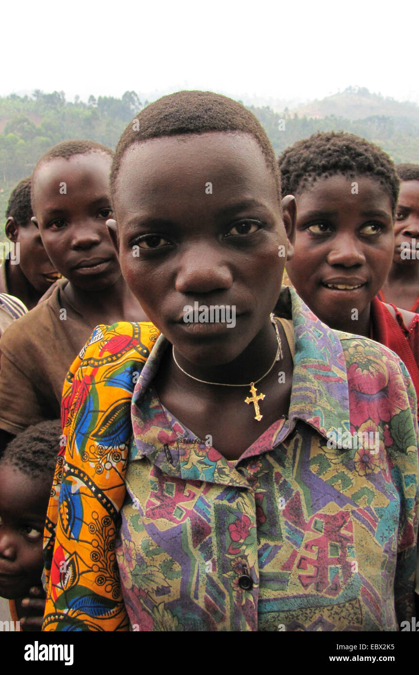 portrait of a girl with a cross on a necklace in front of members of ...