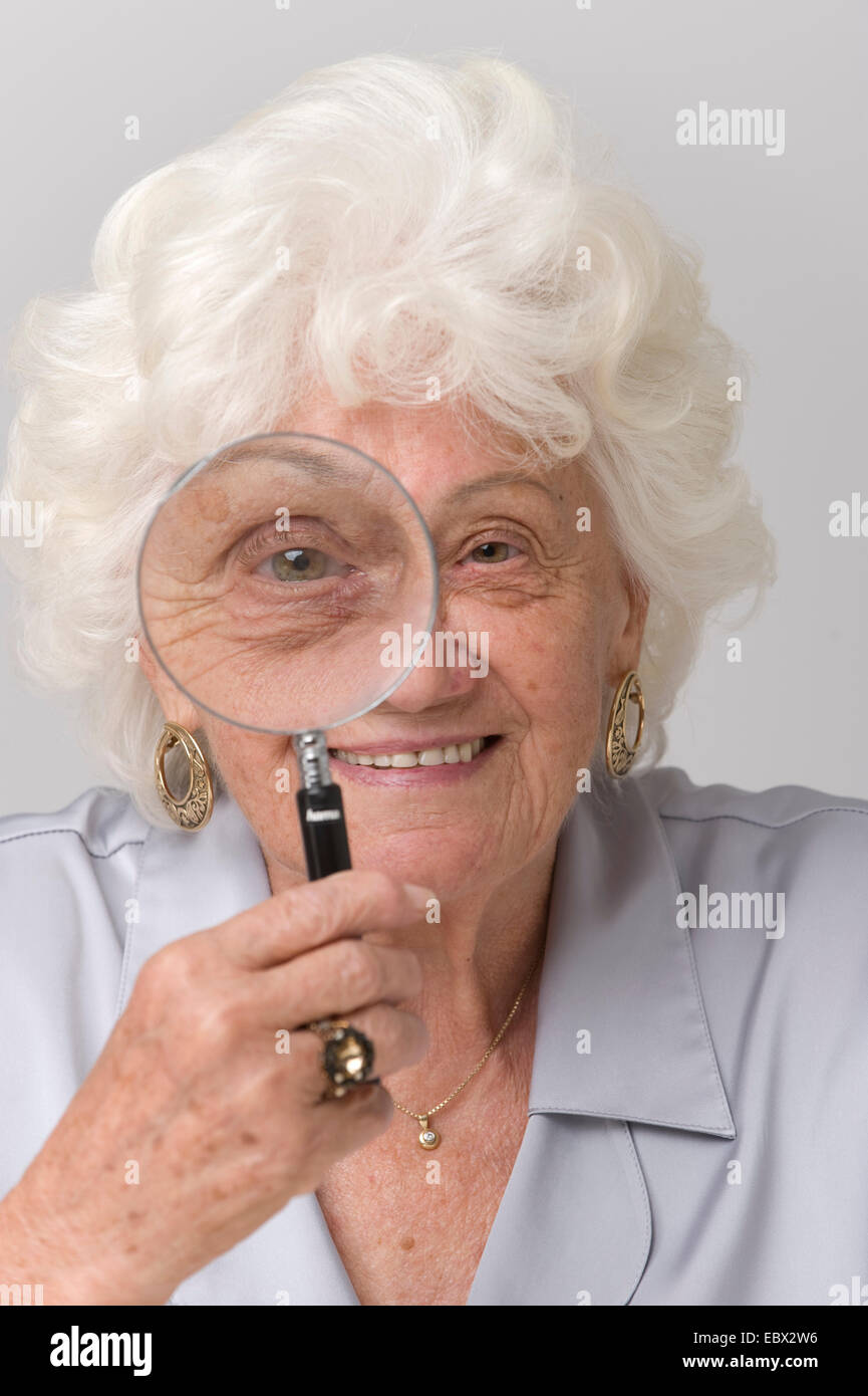 old woman watching through a loupe Stock Photo - Alamy